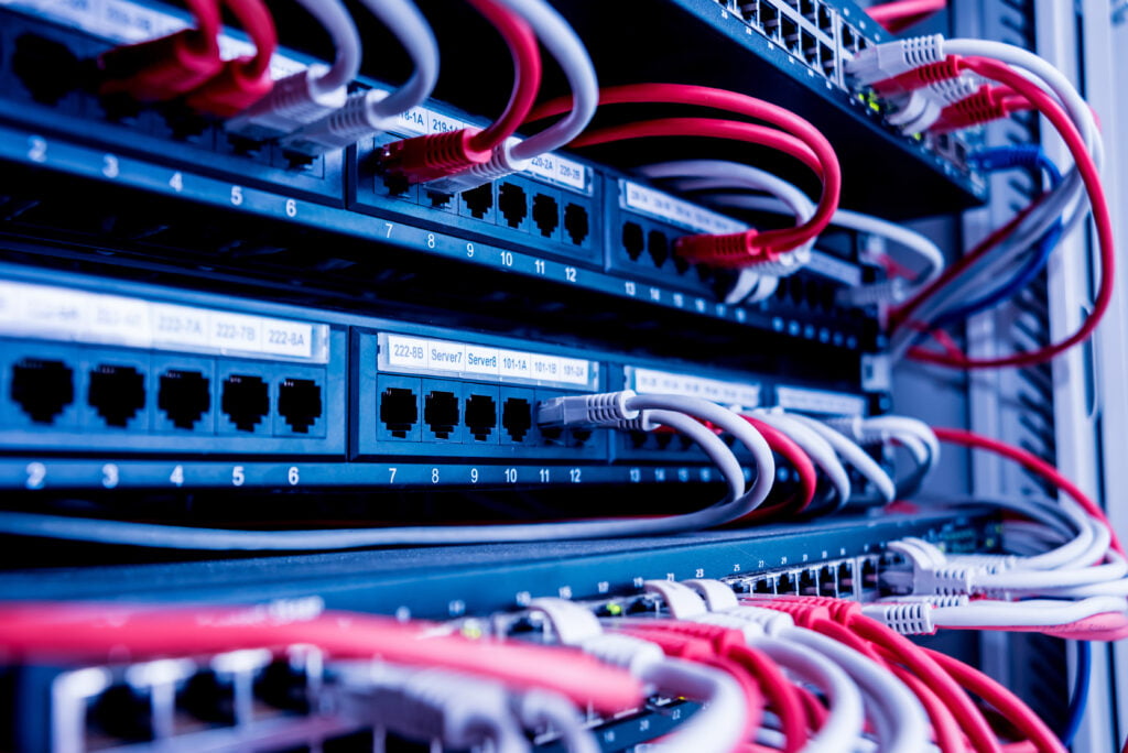 Network switch and ethernet cables in red and white colors. Data Center ...